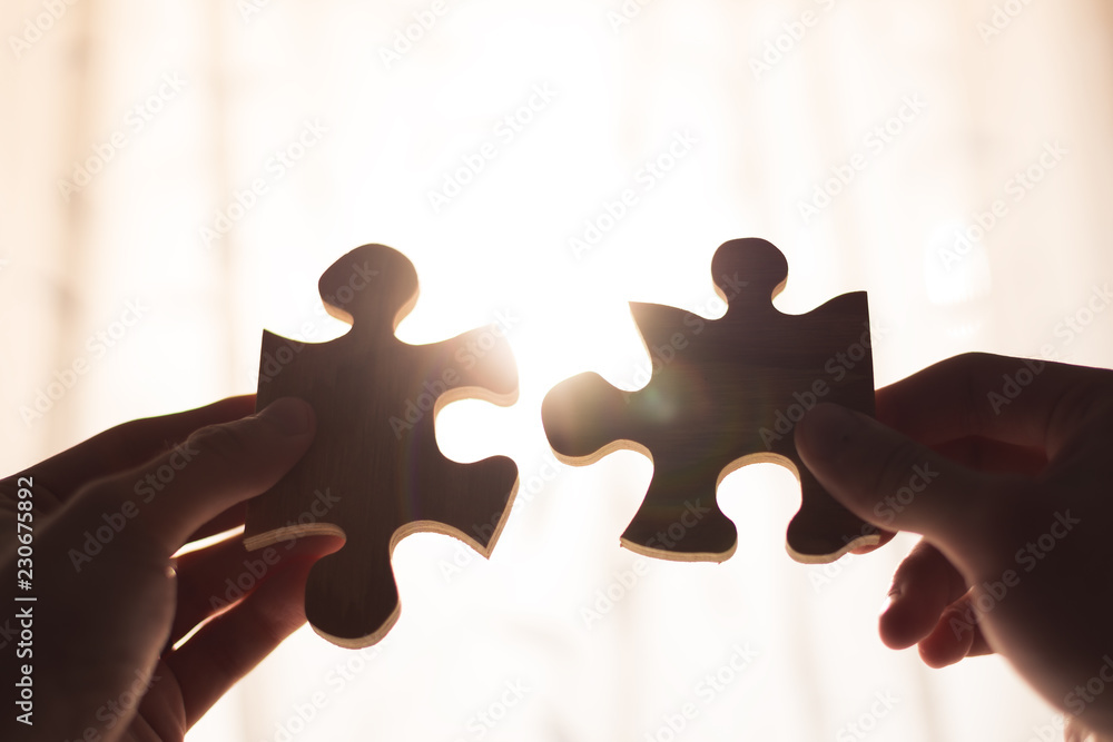 Two hands trying to connect couple wooden puzzle piece. Concept of ...