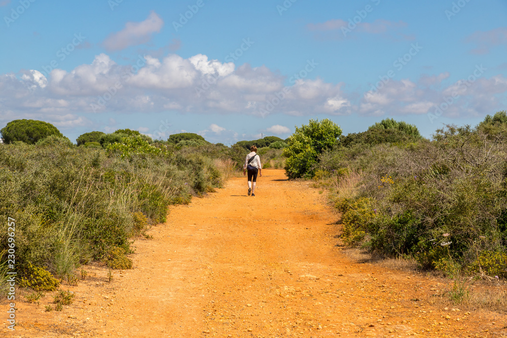 Einsame Frau auf einem Sandweg Stock Photo | Adobe Stock