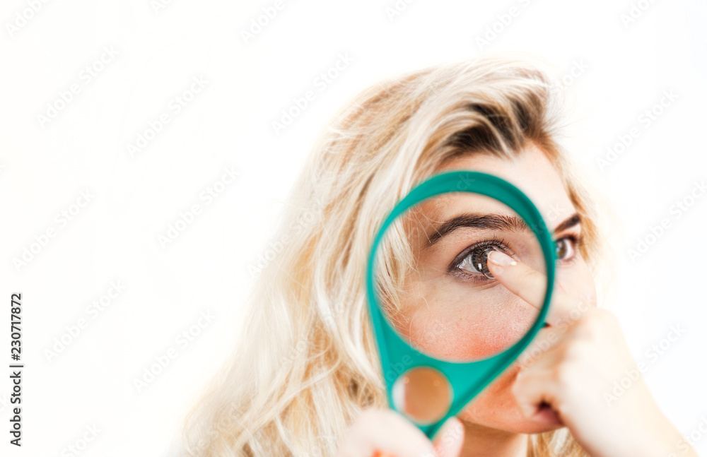 young beautiful girl of European appearance under a magnifying glass ...