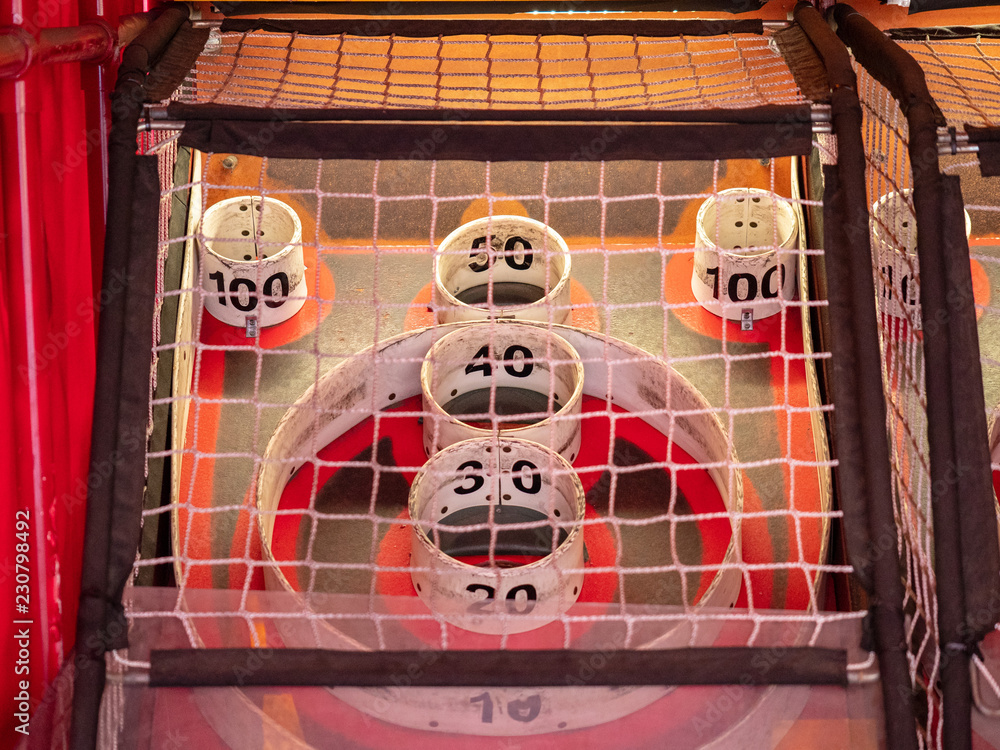 Scoring area of skee ball game behind a net with values of 10 to 100 ...