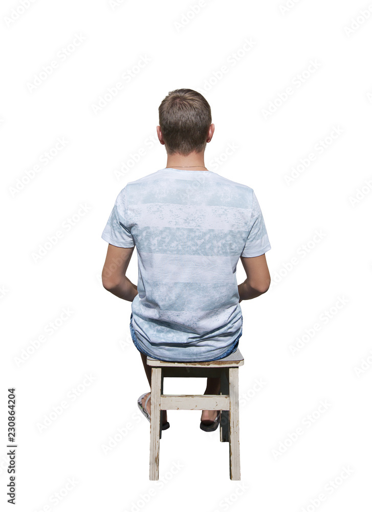 Rear view full length portrait of pensive young man sitting on a old ...