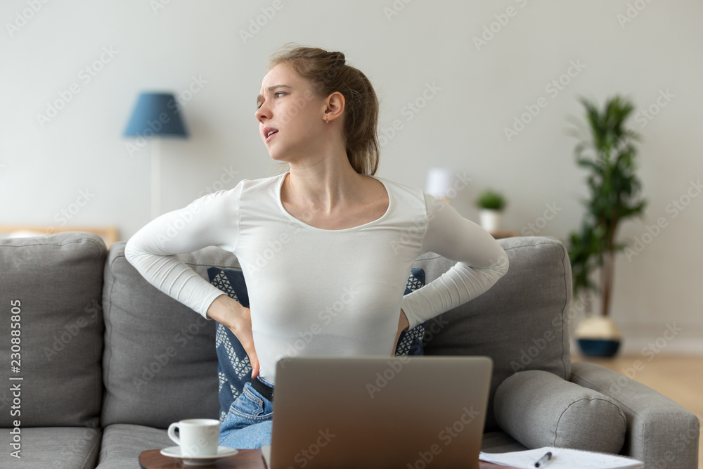 Tired student girl suffers from backache feeling badly, sitting on ...
