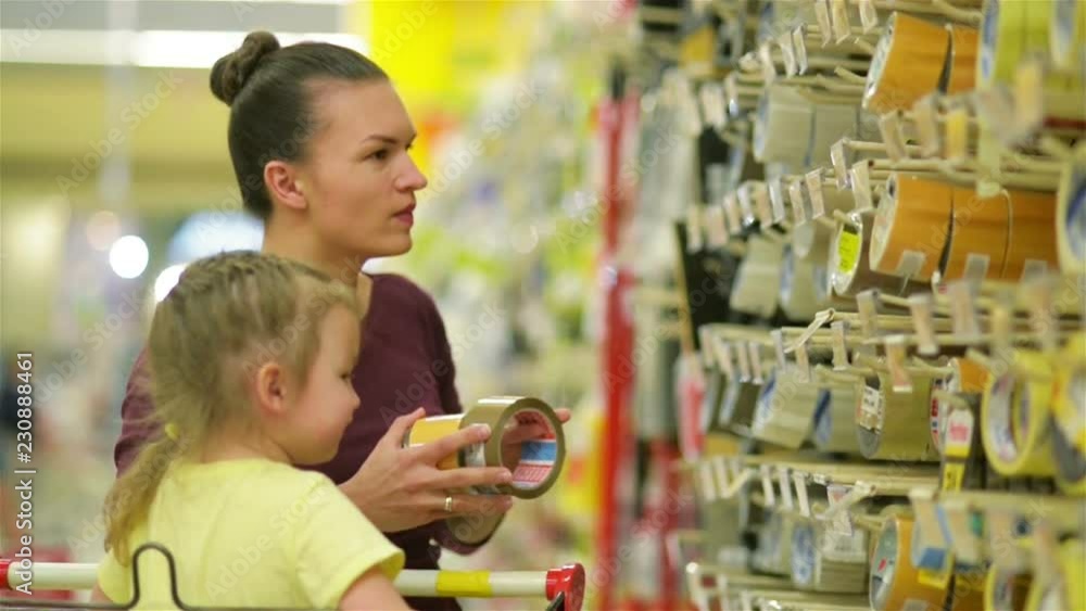 Smiling Mother And Daughter At The Supermarket A Daughter Helps Her