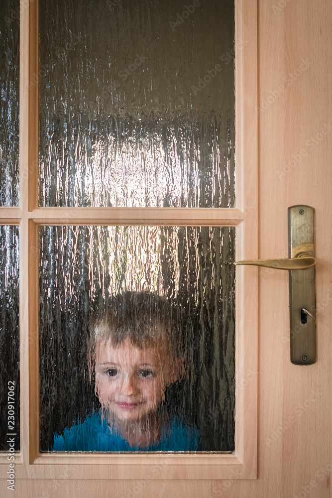 Cute little boy hiding behind a door Stock Photo | Adobe Stock