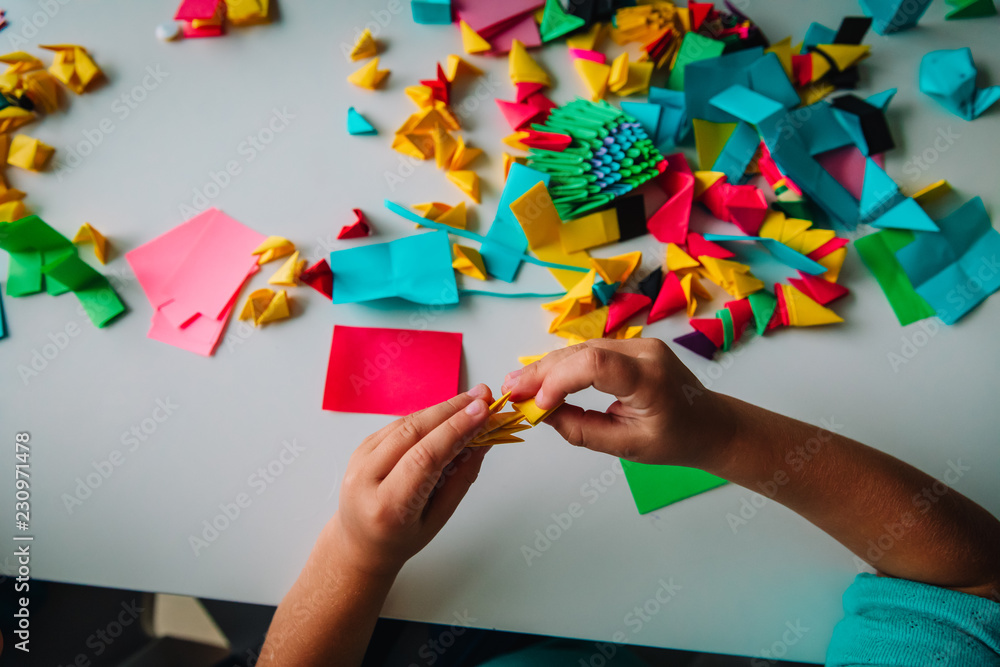 little girl making origami crafts with paper Stock Photo | Adobe Stock
