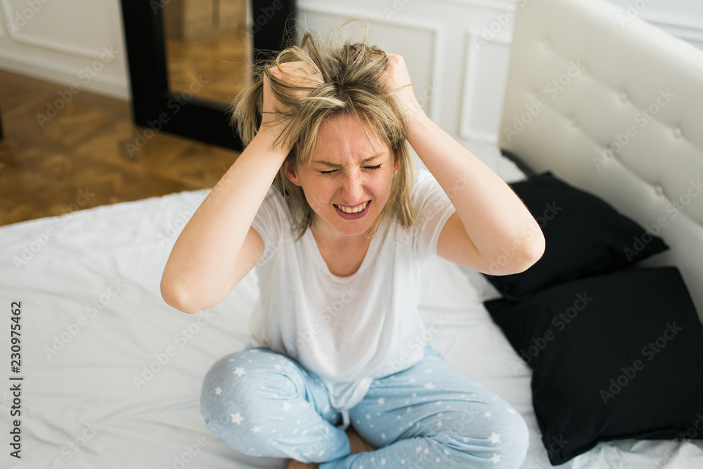 Portrait of a frustrated angry woman screaming out loud and pulling her ...