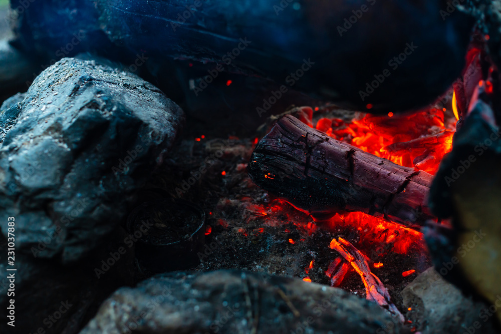 Smoldered logs burned in vivid fire. Atmospheric background with orange ...