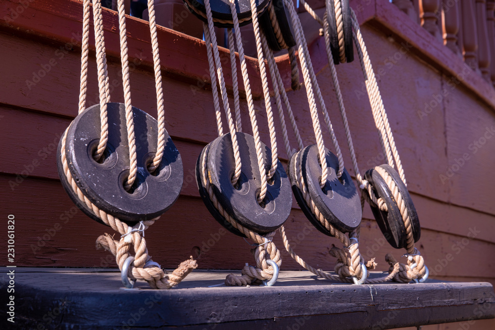 Elements of a ship tackle - four pulleys with ropes attached to a side ...