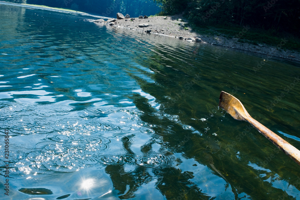 Oar of boat touching water and causing splash and ripples in the water ...