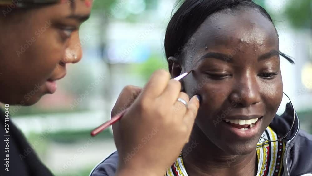African american black woman is having her makeup done outdoors by a ...