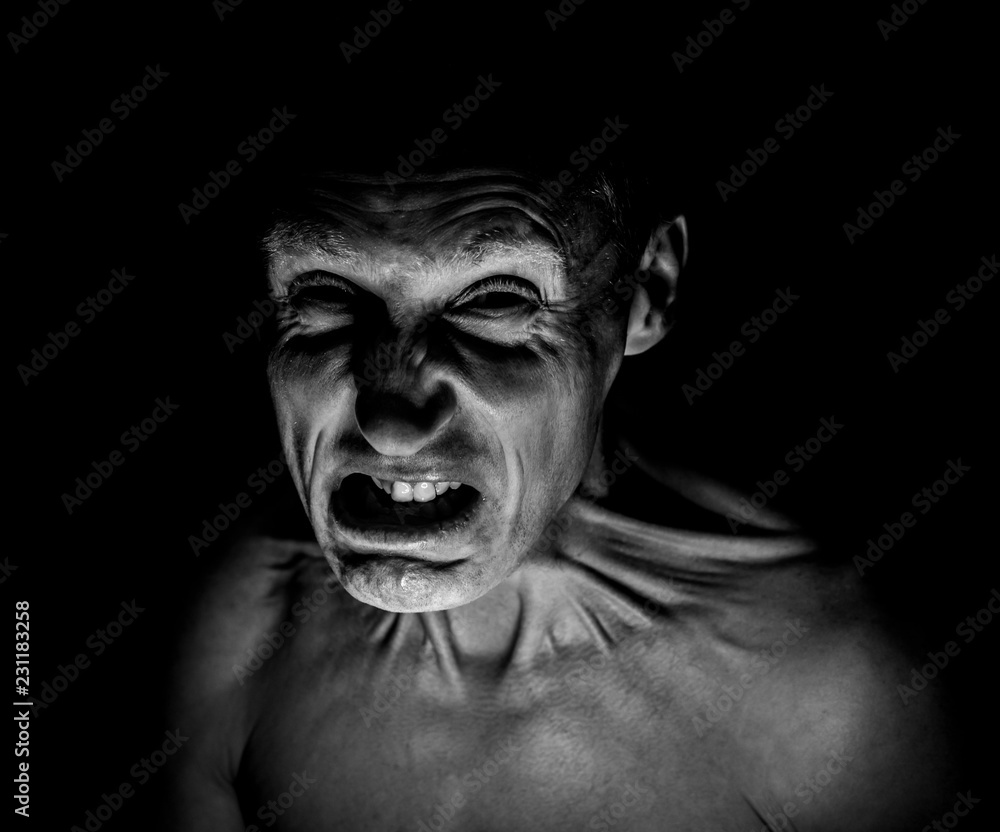 Stylish dark portrait of feared adult caucasian man who wrinkles his ...