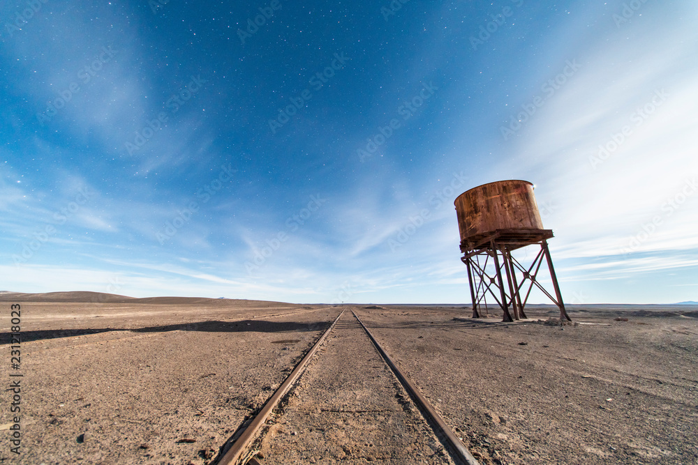 Old and abandoned railway track and station with it water tank to fill ...
