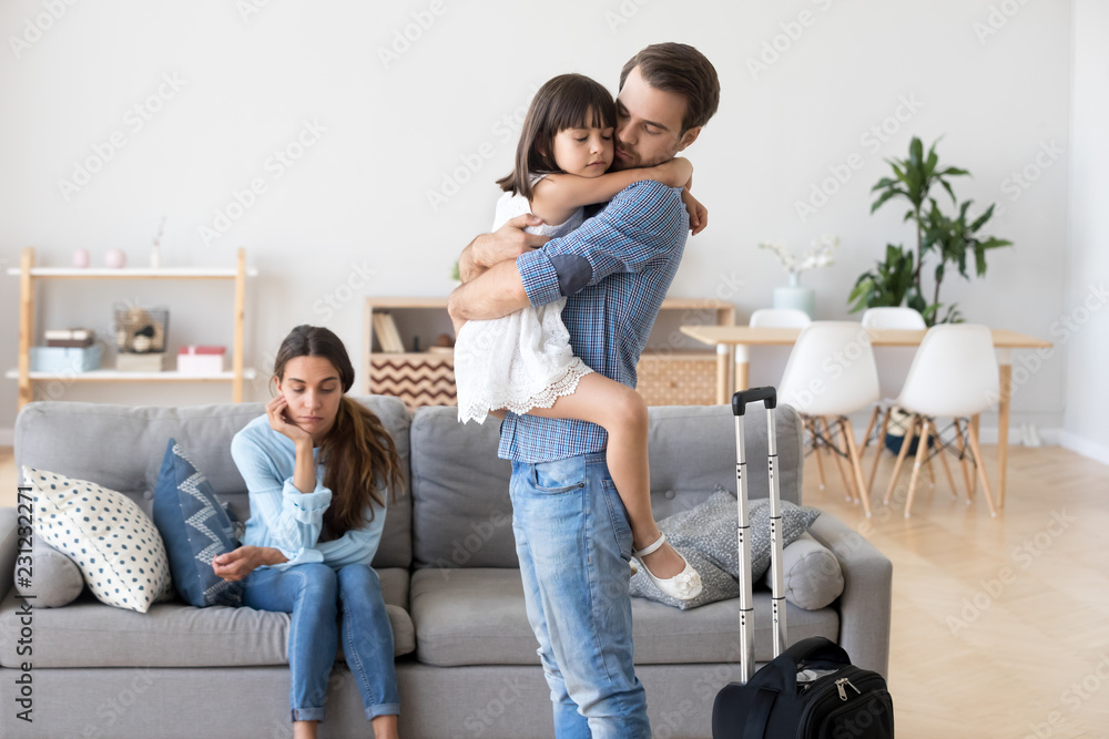 Unhappy diverse family in living room at home. Sad father hugs hold on ...