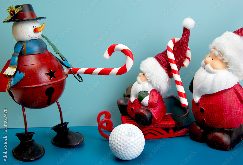 Snowman is playing golf with candy cane as golf club. Two Santa Clauses ...