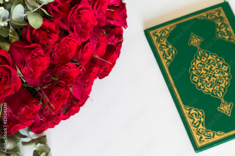 Koran and rosary beads on the white background with red roses for ...