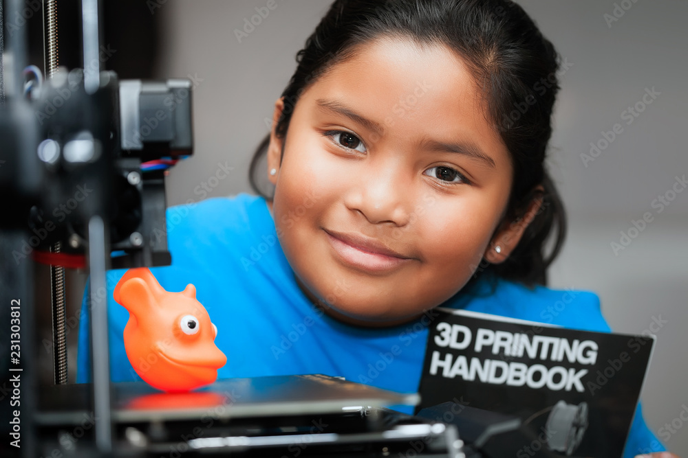 Cute girl smiling and showing her 3d printed creation on the bed of a ...