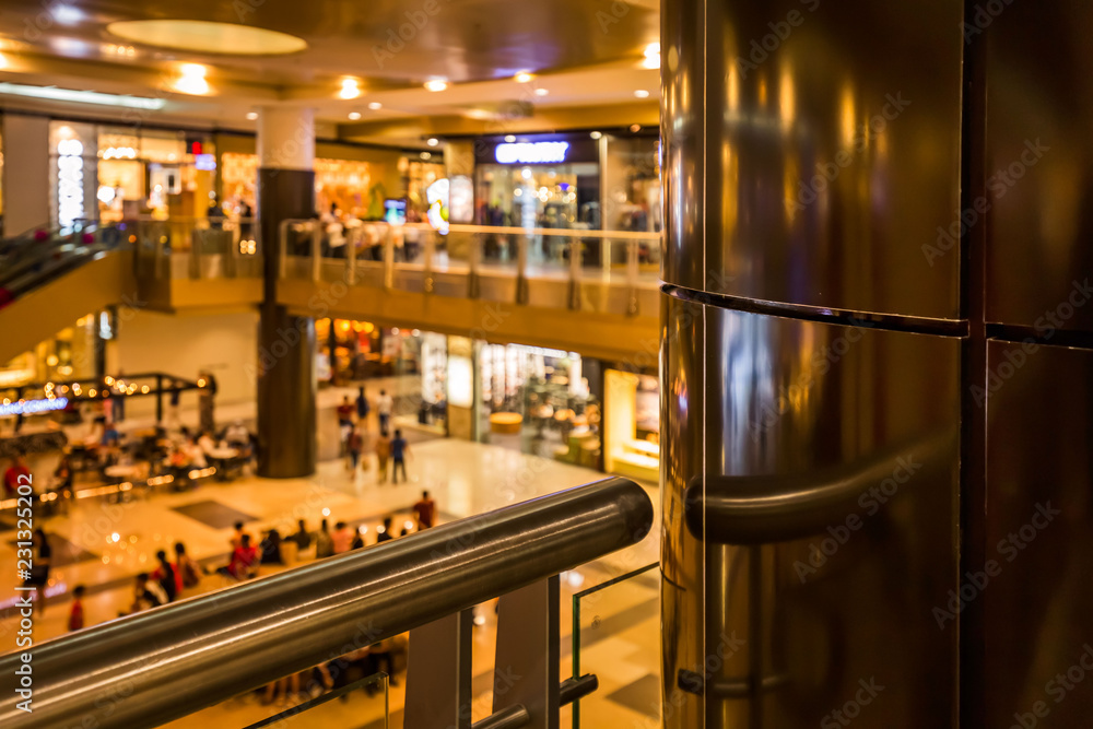 Handrail and light reflection in a shiny column in a shopping mall with ...