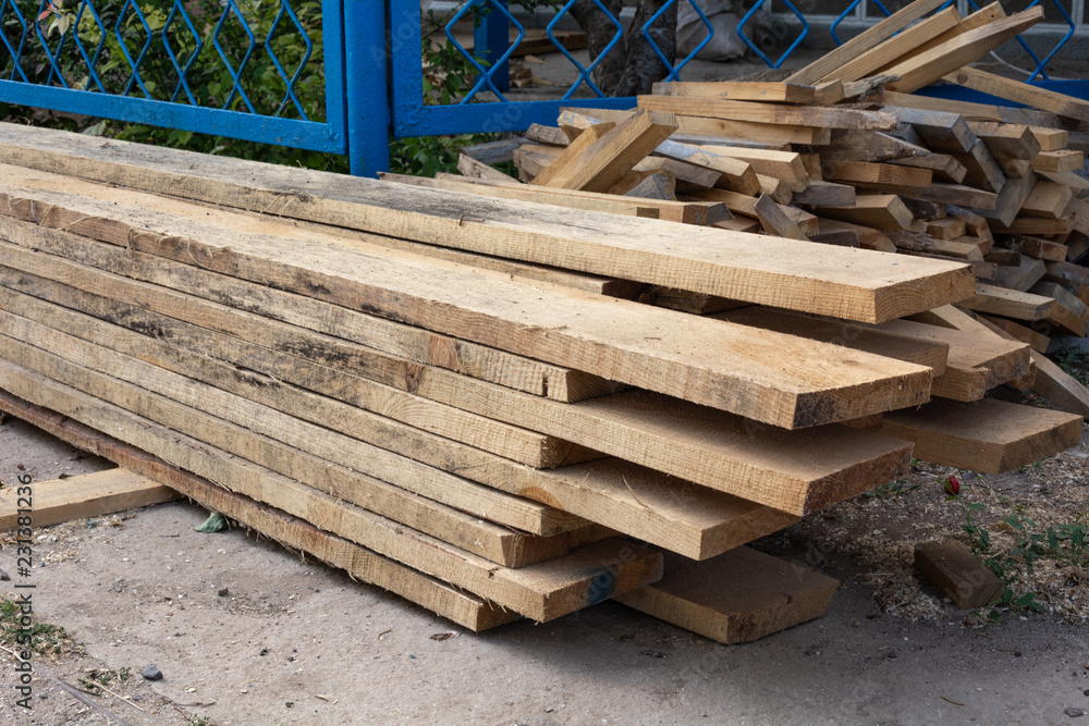 Pine wood timber stack of natural rough wooden boards on building site ...