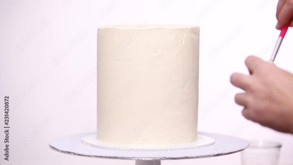 Step by step. Applying glitter dust on tall birthday cake with white ...
