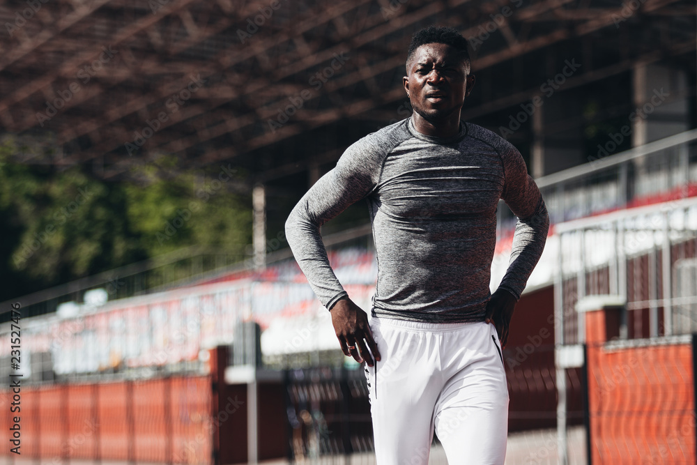 African-American sportsman and athlete training on a running track ...