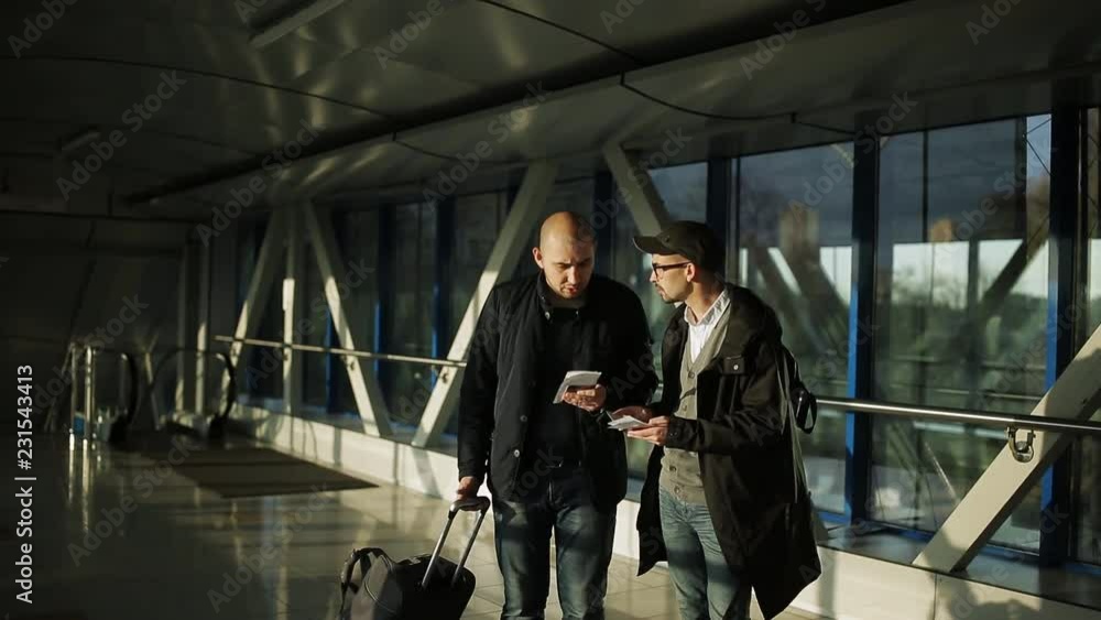 Two men in the corridor of the airport to communicate in anticipation ...