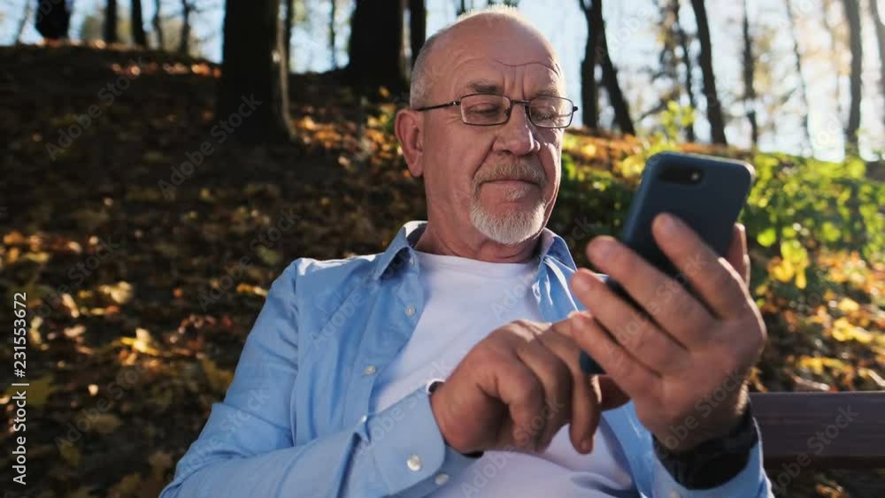 Senior man using mobile phone, holding smart phone, texting, surfing ...