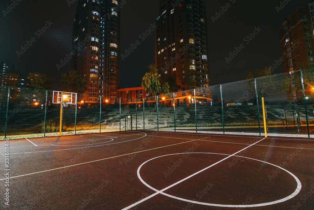Illuminated basketball playground with red pavement, modern new ...