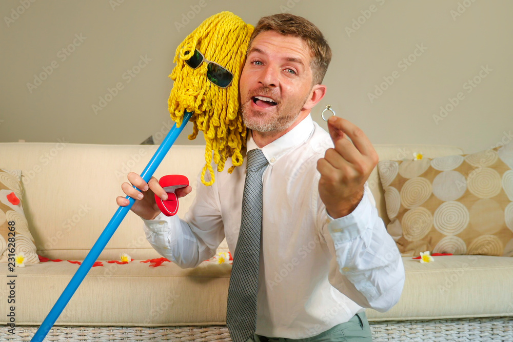 funny portrait of young weird crazy and happy man holding mop with ...