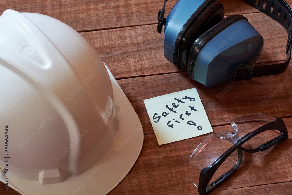 Safety first note one yellow piece of paper stuck on wooden background ...