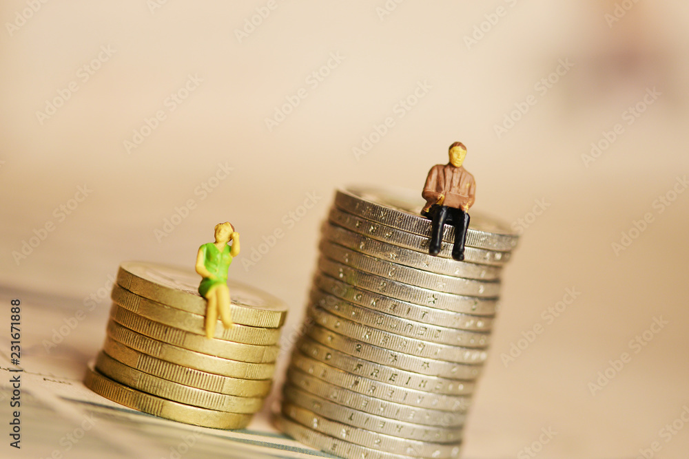 Income inequality by gender with human miniature silhouettes on pile of ...