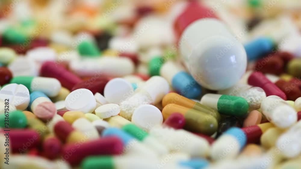 Closeup view of large pill and many small pills spinning Stock Video ...