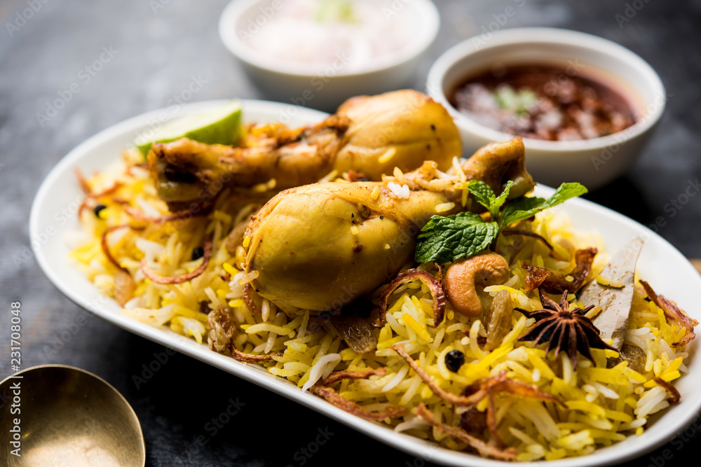 Delicious spicy chicken biryani in bowl over moody background, it’s a ...