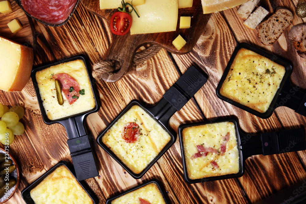 Delicious traditional Swiss melted raclette cheese served in individual ...