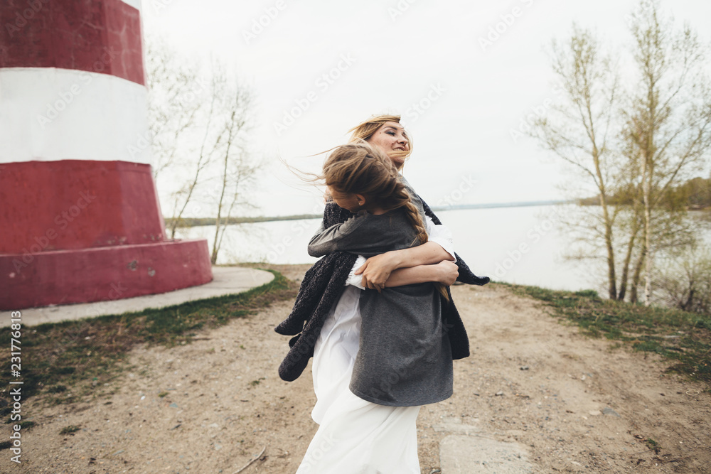 Woman enbrace her daughter at the lighthouse Stock Photo | Adobe Stock