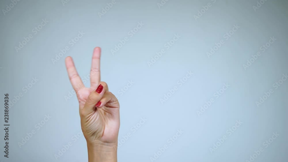Woman raising two fingers up and showing peace or victory symbol or ...