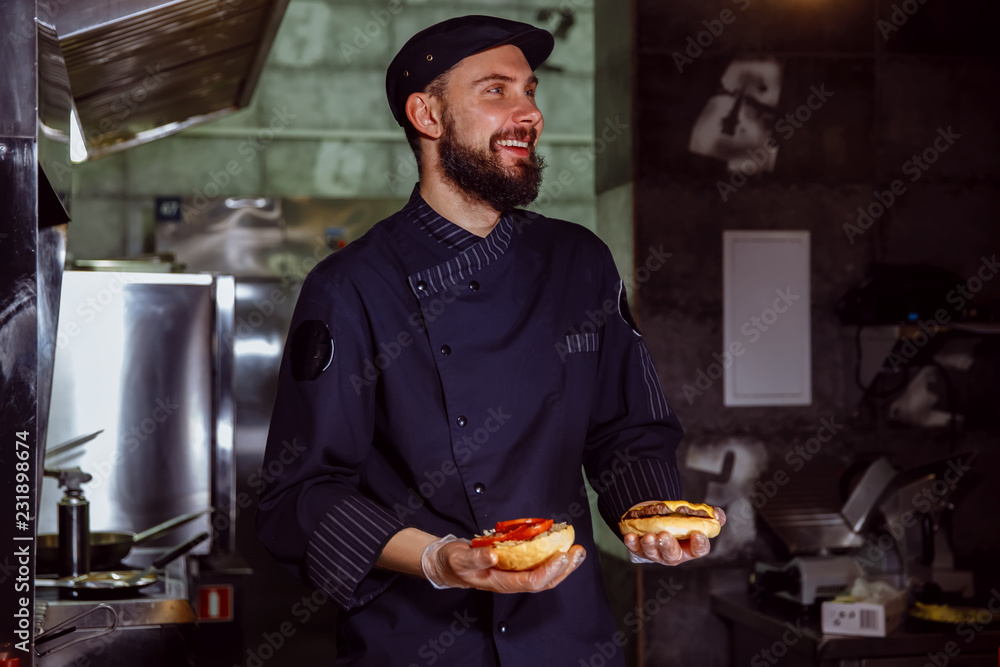 Chef putting bun on top,he making a beef burger for customer order ...