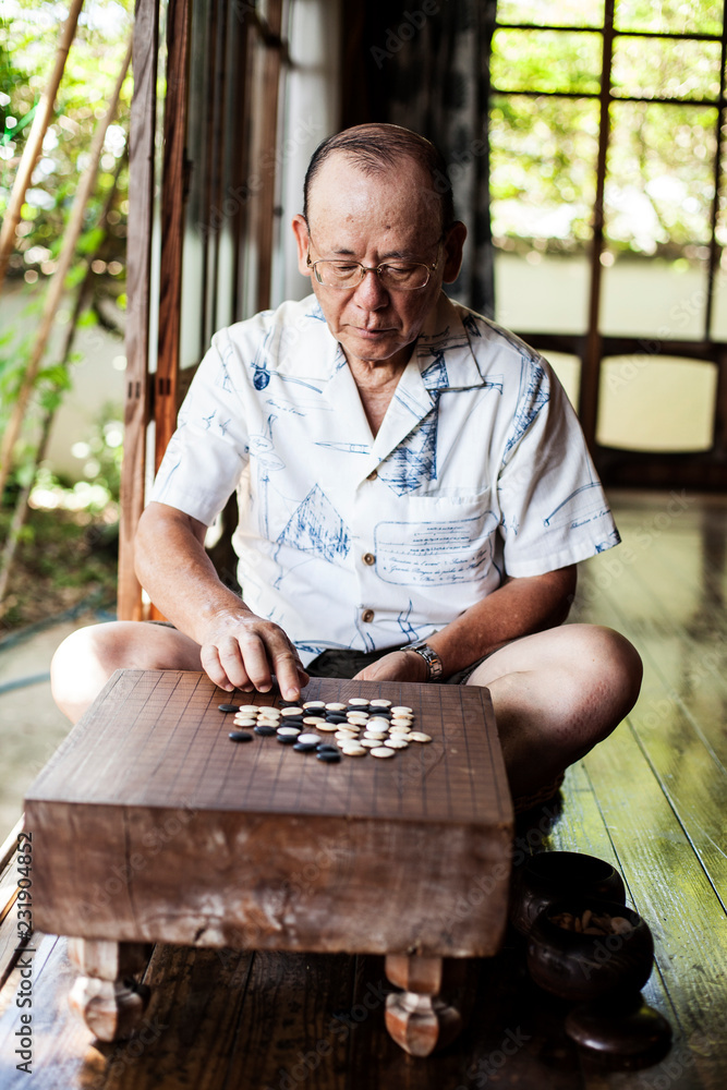 Japanese man sitting on floor on porch of traditional Japanese house ...