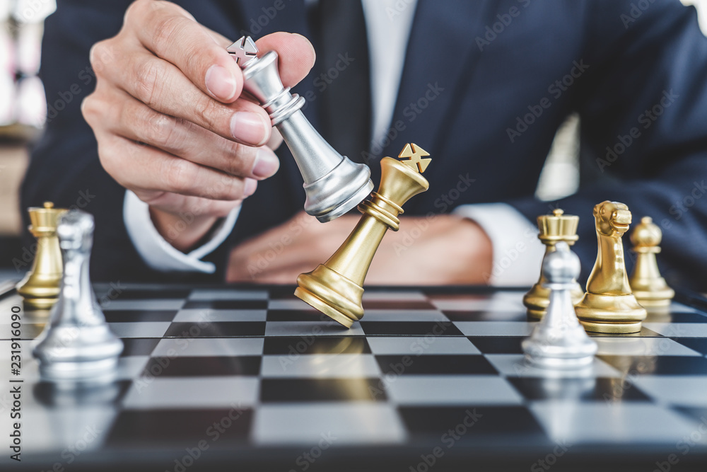 Businessman playing chess game reaching to plan strategy for success ...