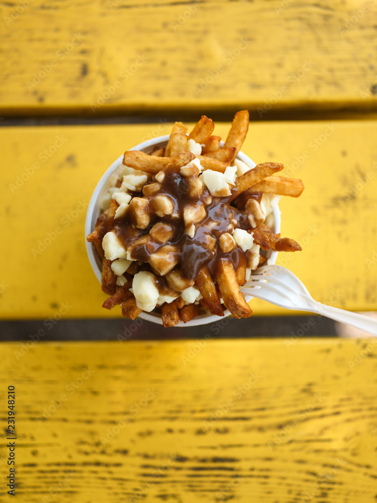 Poutine on a yellow picnic table from above Stock Photo | Adobe Stock