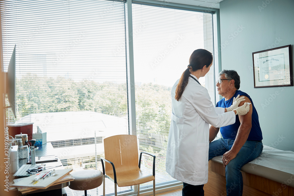 Doctor giving male patient a shot in the arm Stock Photo | Adobe Stock