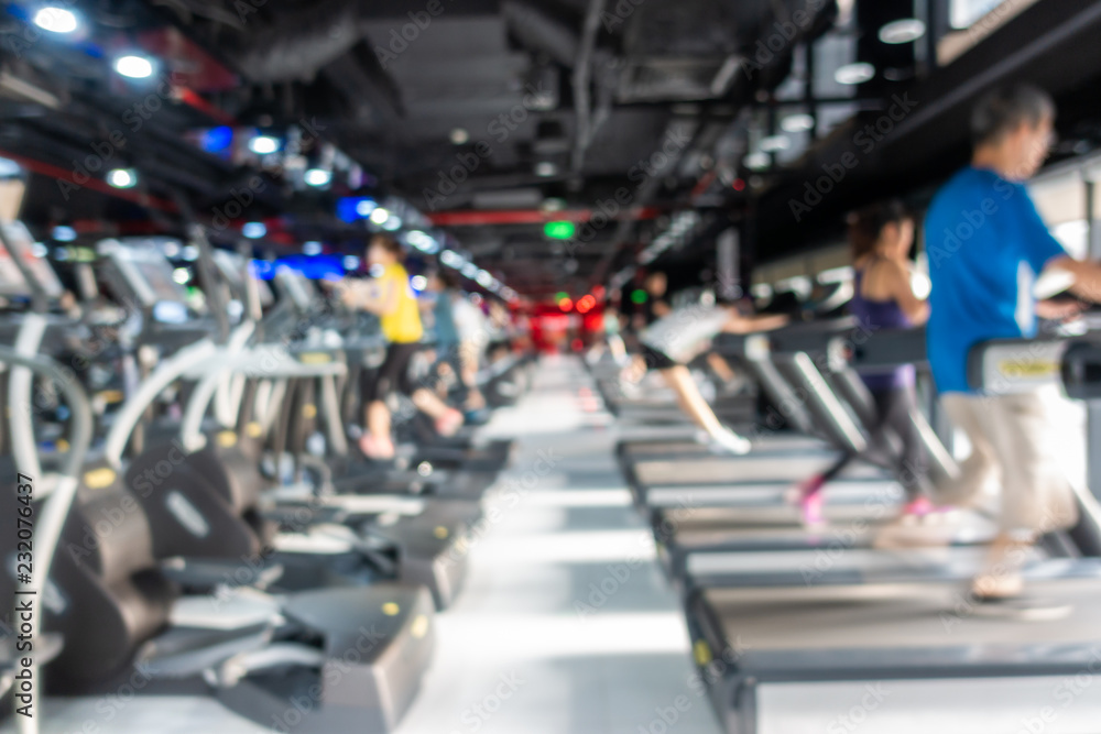 Blurred of fitness gym center interior background with two rows of ...
