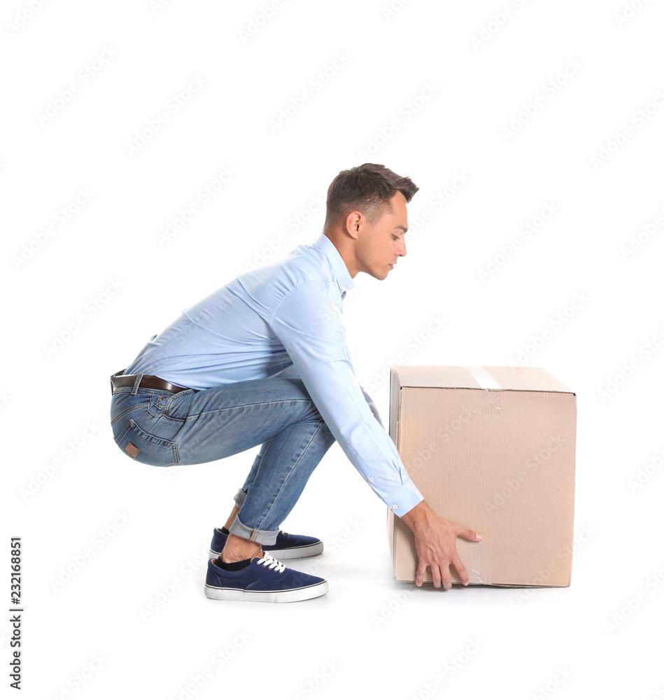 Full length portrait of young man lifting heavy cardboard box on white ...