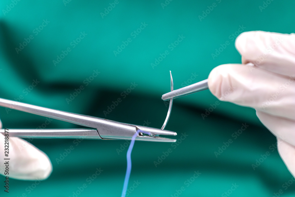 Doctor holding surgical forceps suture needle, suturing material Stock ...
