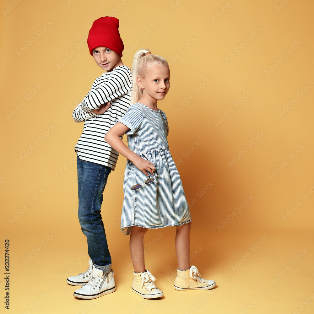 Cute boy and girl in fashionable clothes on color background Stock ...