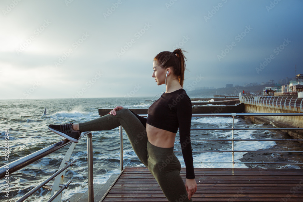 Fitness model athlete girl warm up stretching her hamstrings, leg and ...