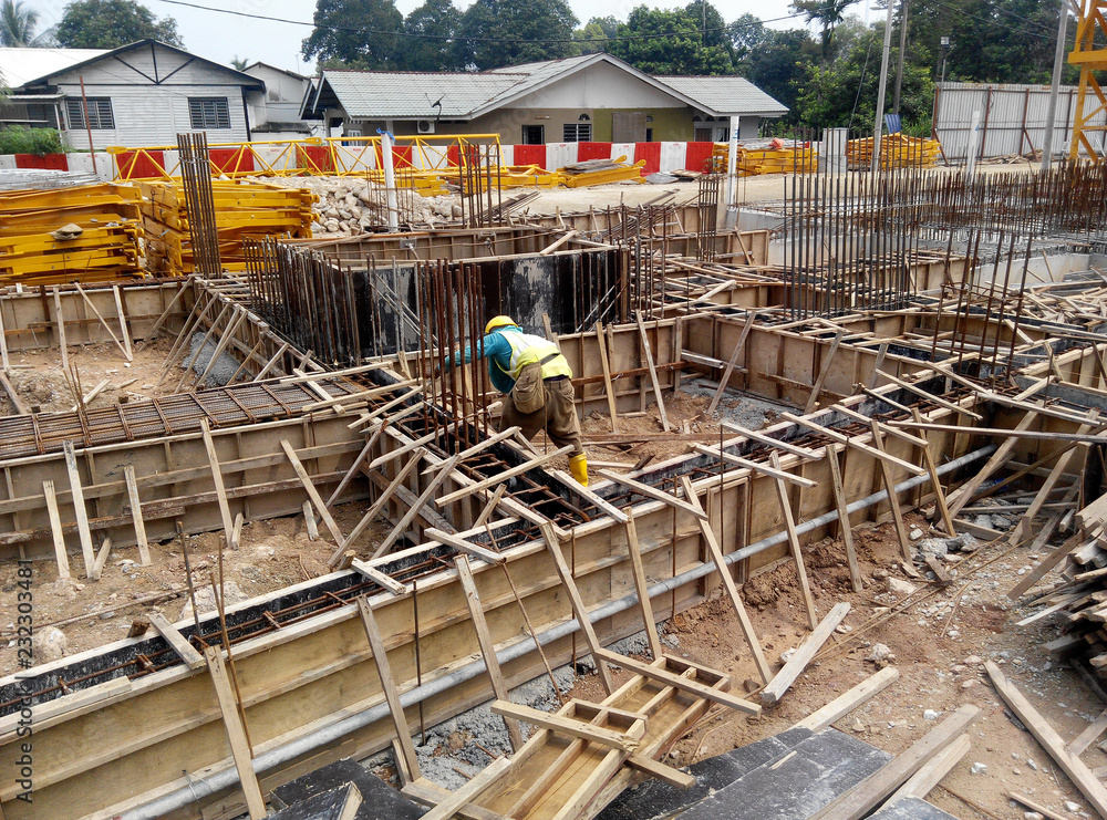 Ground beam form work constructed by workers at the construction site ...
