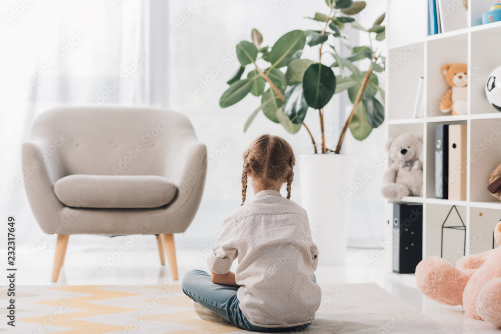 rear view of little child sitting on floor of empty room Stock Photo ...