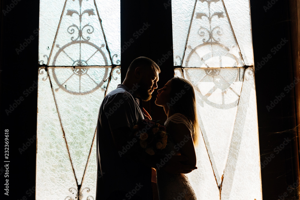 portrait of a romantic couple in a backlight from a window or door ...