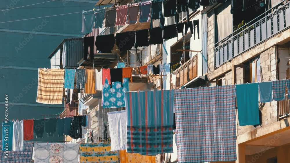 Clothes hanging and drying on a rope on a multi-story building in a ...
