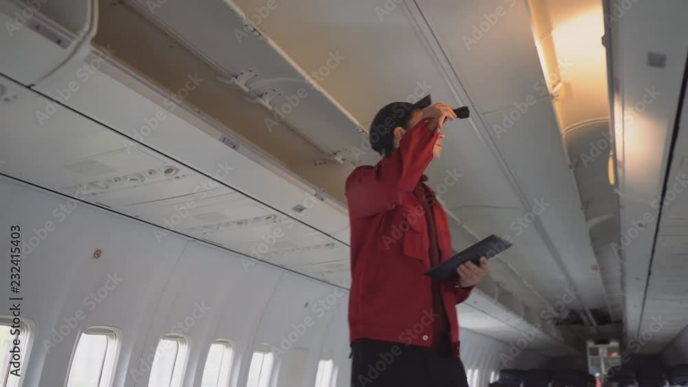 Repair of passenger aircraft cabin. Mechanic conducts inspection of the ...